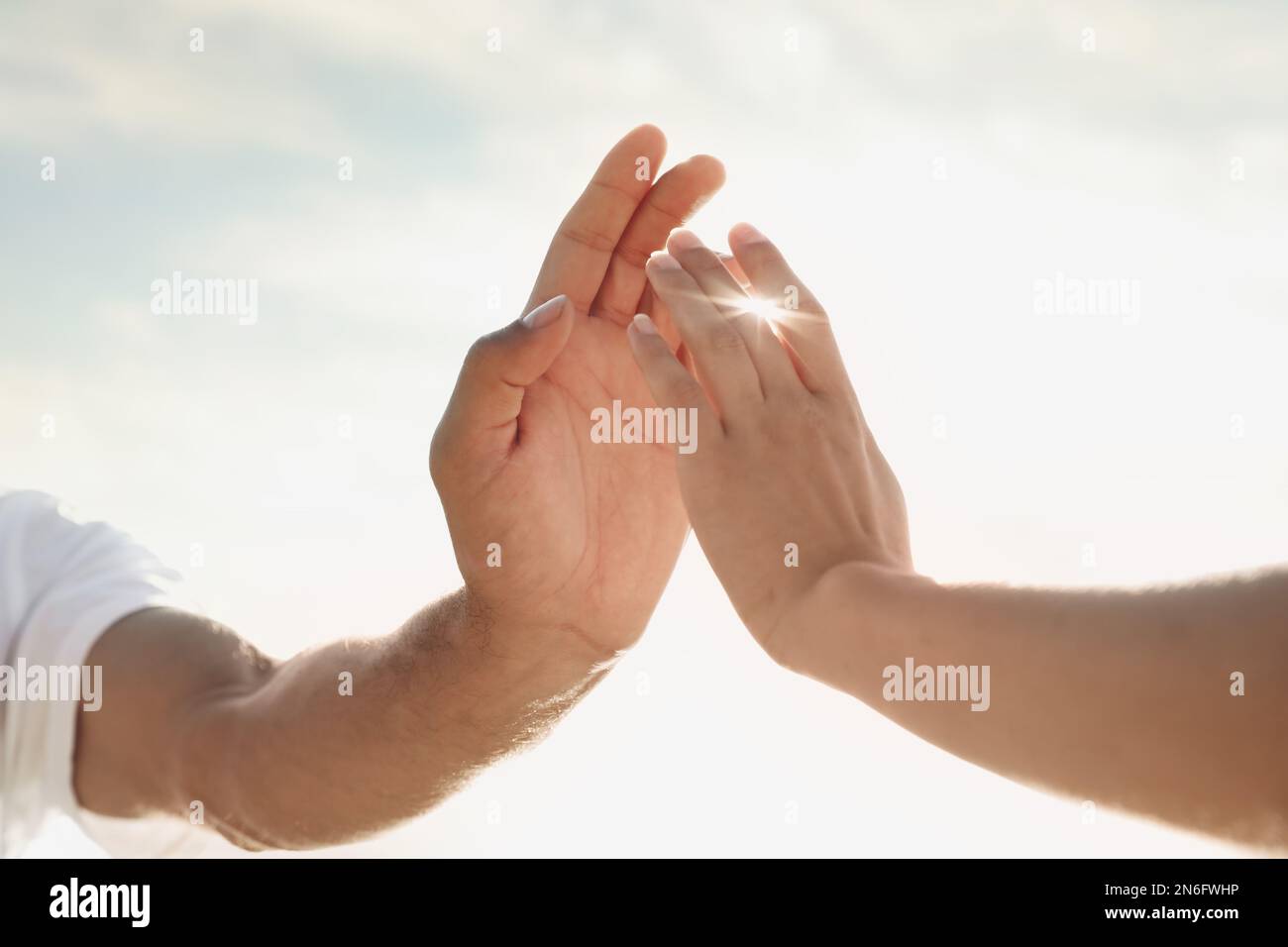 Man and woman reaching hands to each other at sunset, closeup. Nature ...