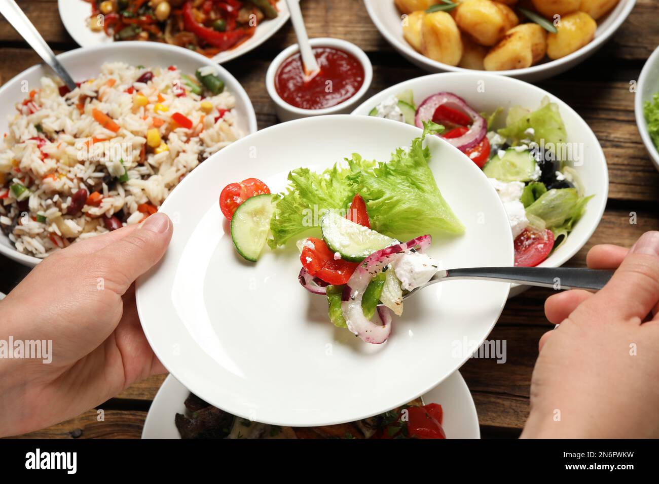 Woman taking food from buffet table, closeup Stock Photo - Alamy