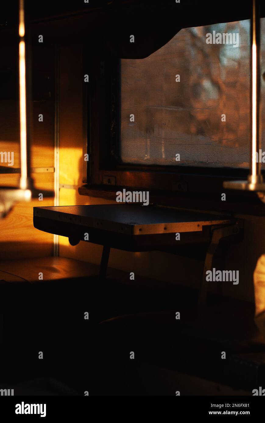 Seats and table in train in the morning light Stock Photo - Alamy