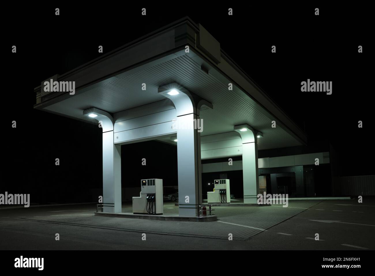Modern gas station with convenience store beside the road at night ...