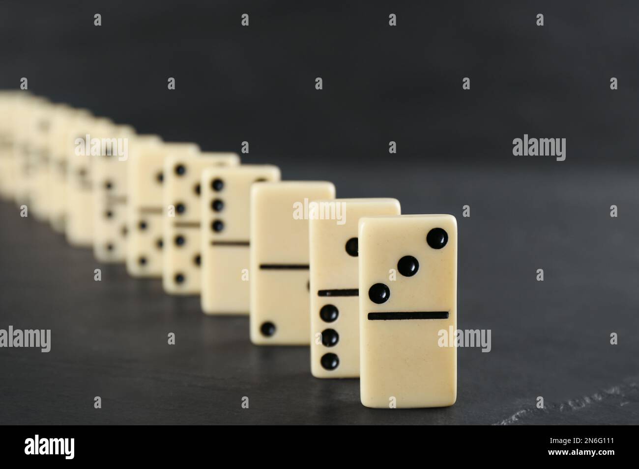 White domino tiles with black pips on dark grey table Stock Photo - Alamy