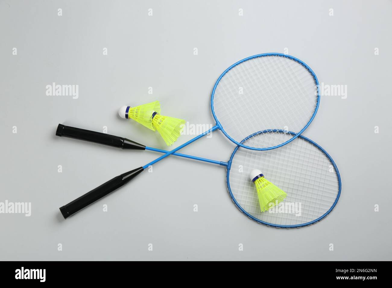 Rackets and shuttlecocks on light grey background, flat lay. Badminton ...
