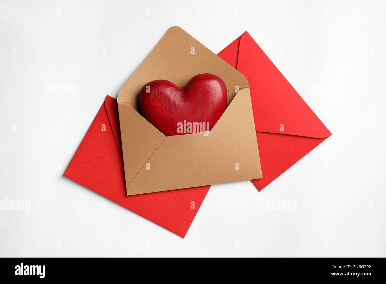 Decorative heart in envelope on white background, flat lay. Love ...