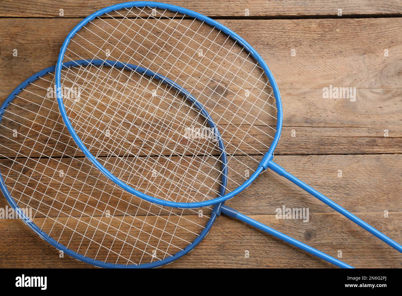 Rackets on wooden table, flat lay. Badminton equipment Stock Photo - Alamy