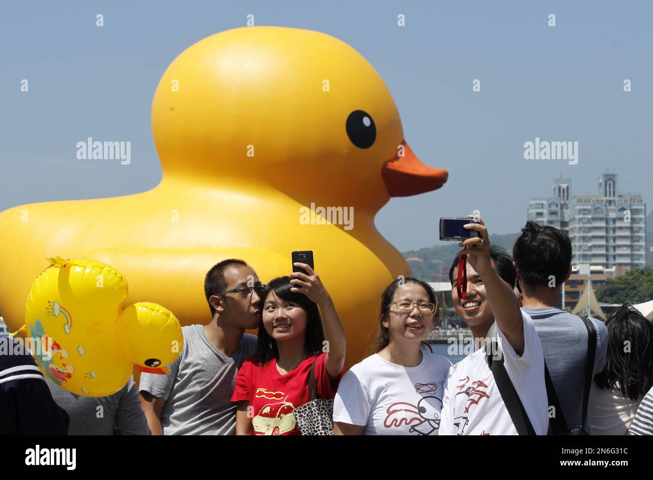 Visitors pose for photos in front of a giant rubber duck in the port of ...