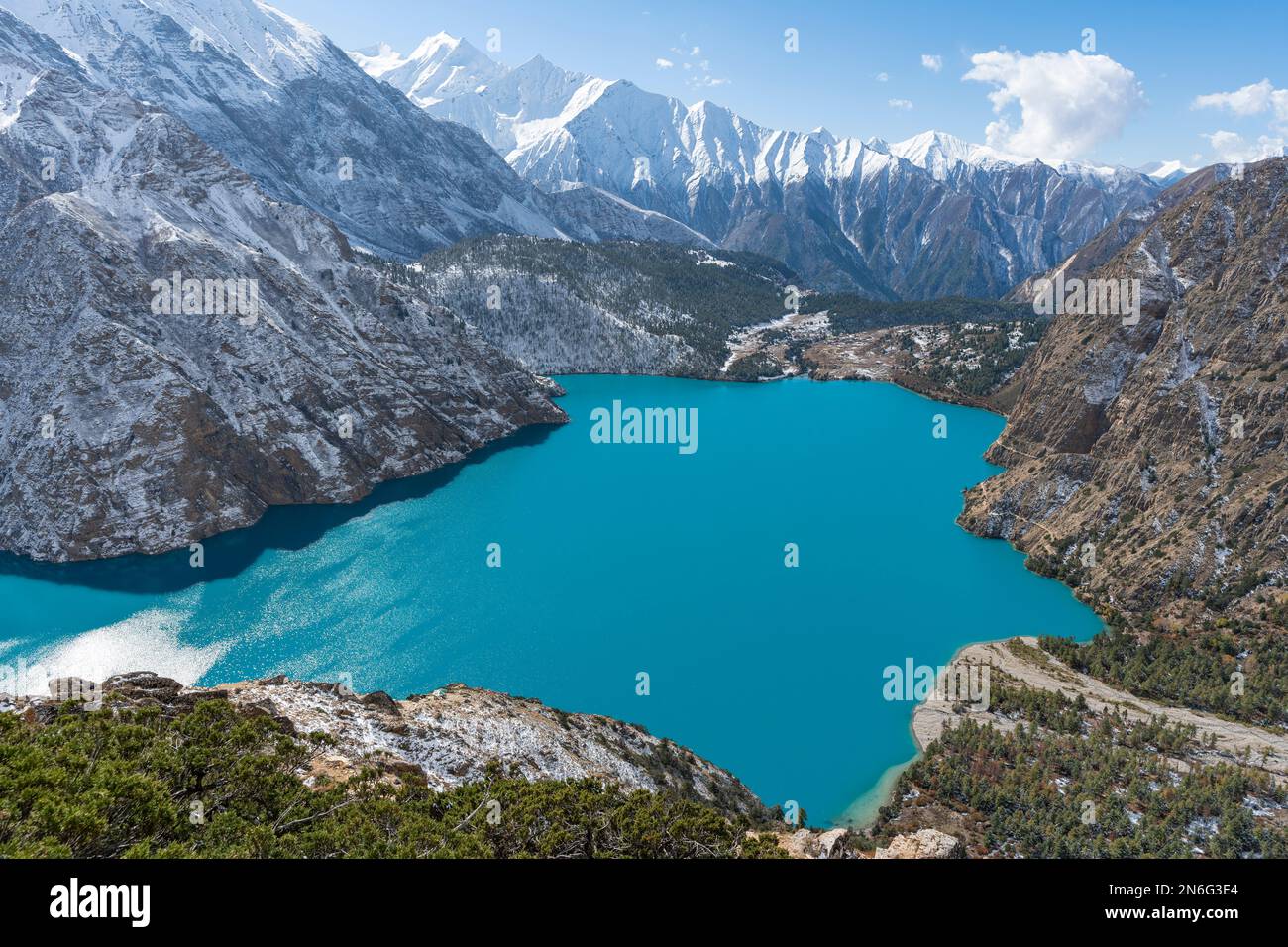 A drone shot of Phoksundo lake surrounded by mounts, in Shey Phoksundo ...