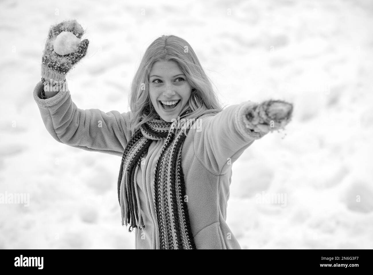 Happy young girl playing snowball fight. Portrait of a happy woman in ...