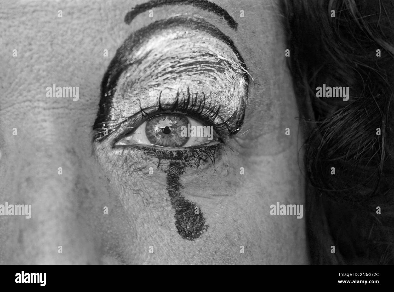 Woman with painted tear on eye, woman made up as clown, crying woman ...