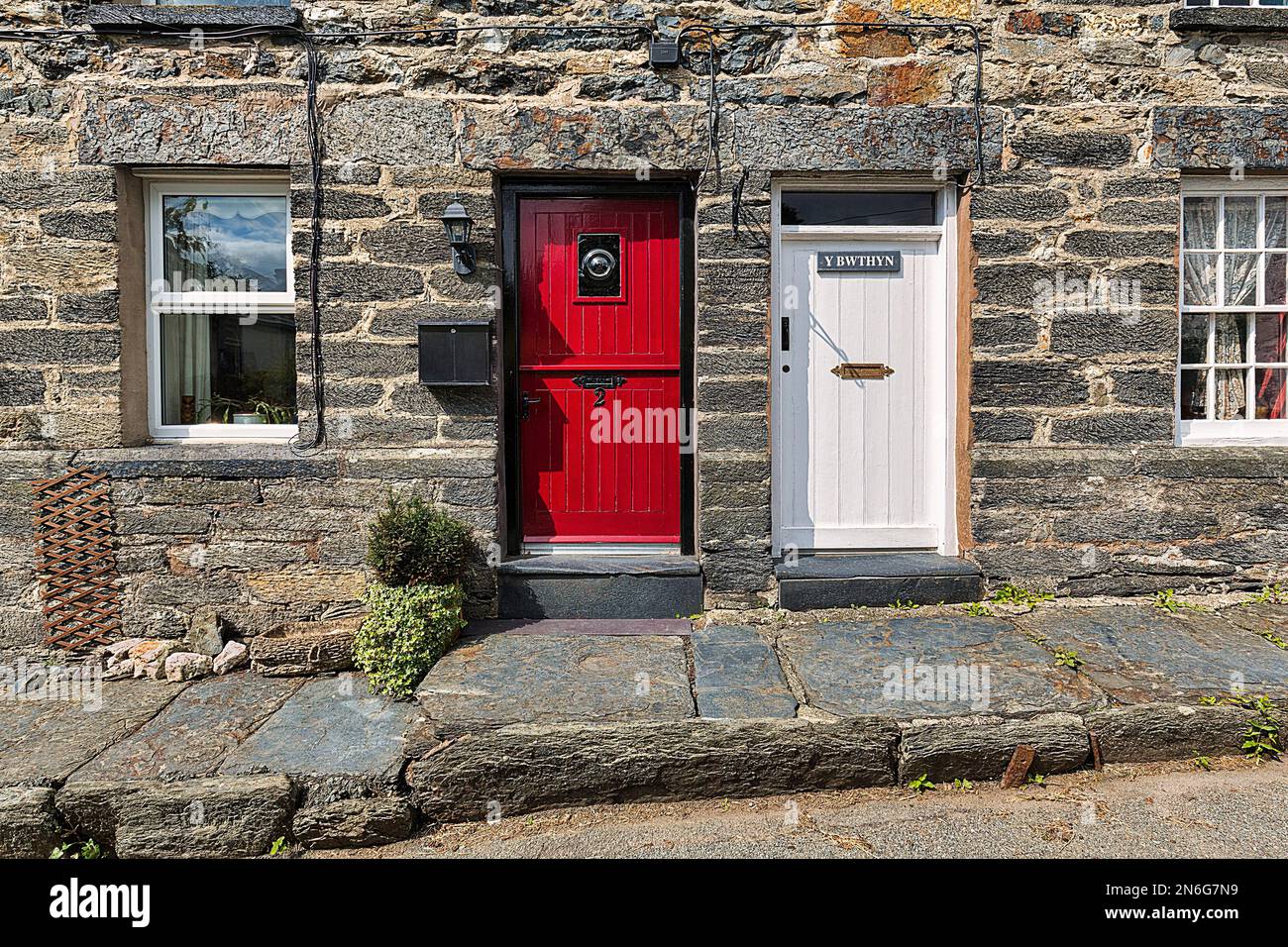 Traditional stone house with two different coloured doors, red and ...