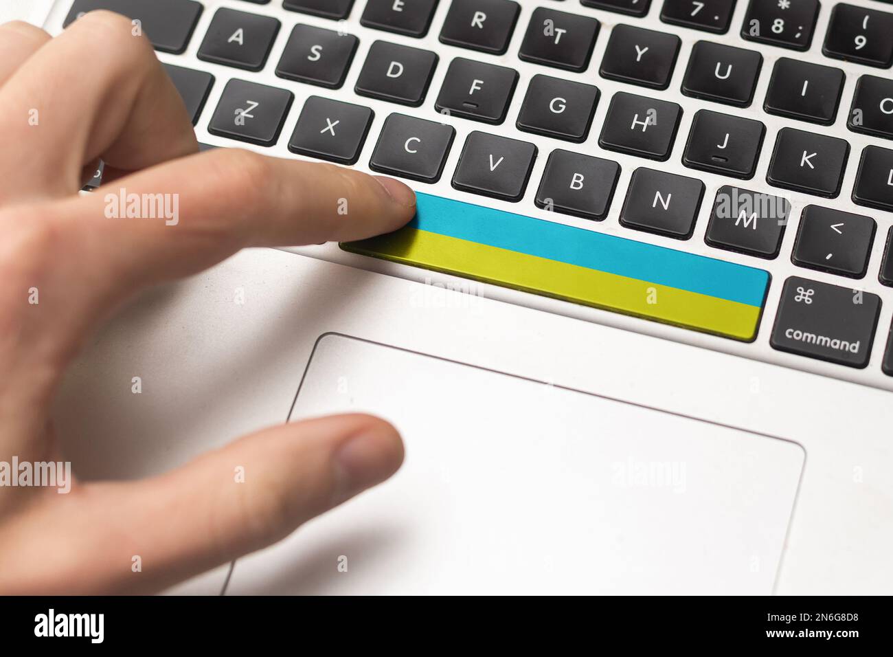 Pressing enter button with Ukraine flag, represents a cyber-attack of ...