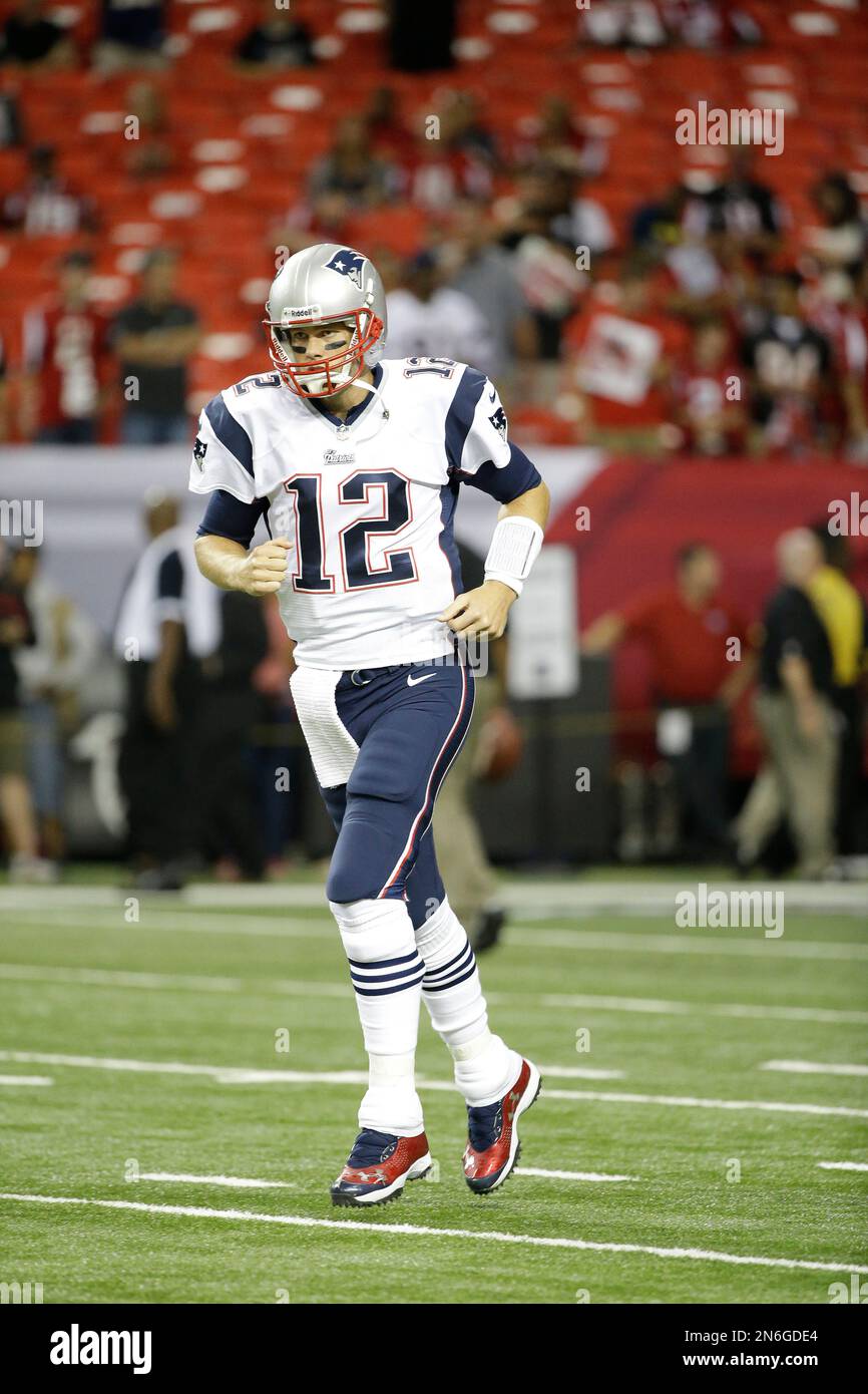 New England Patriots quarterback Tom Brady (12) takes the field to warm ...