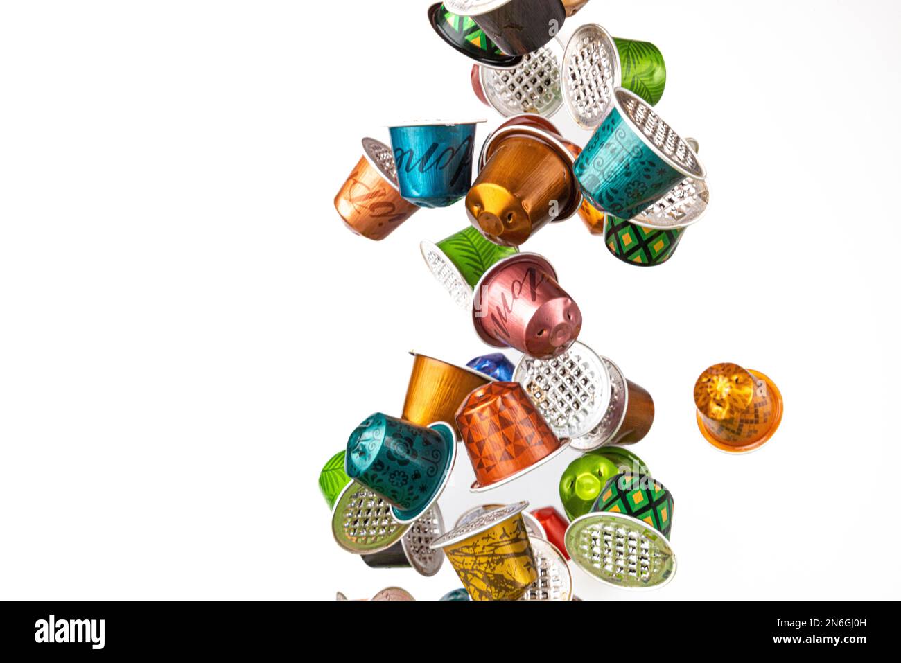Different coloured used coffee capsules, flying, white background Stock ...
