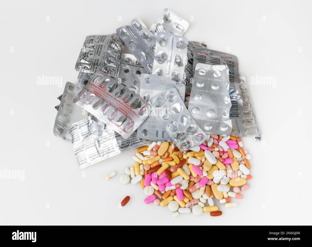 Empty blister packs with, coloured pills and capsules, white background ...