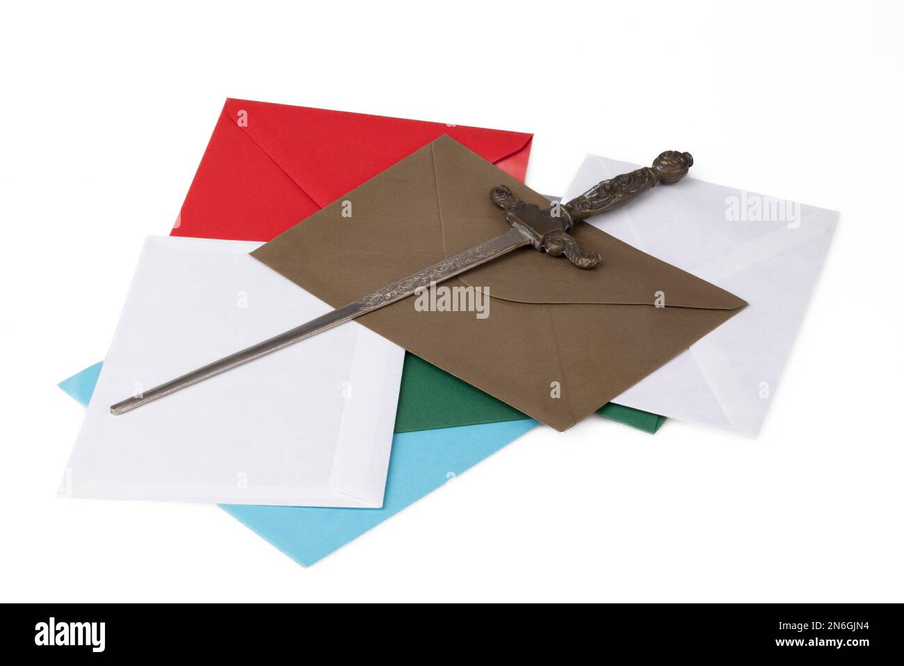 Coloured envelopes, old letter opener in sword shape, white background ...