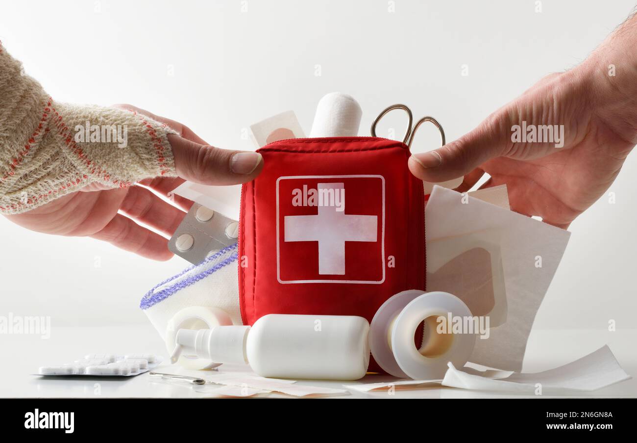 First aid kit concept with hands picking up bag full of tools and ...