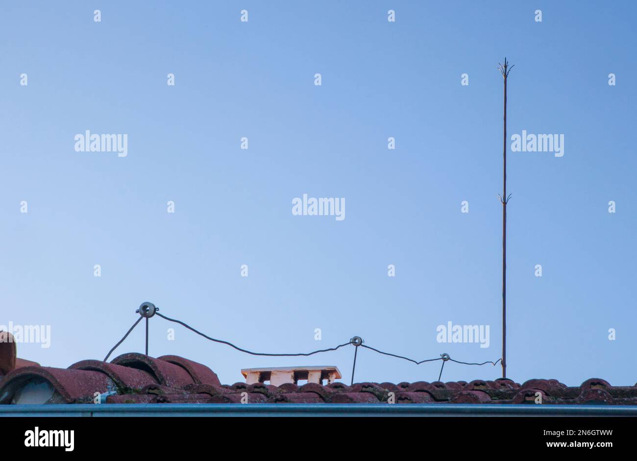 Traditional lighting rod over tile roof. Blue sky background Stock ...