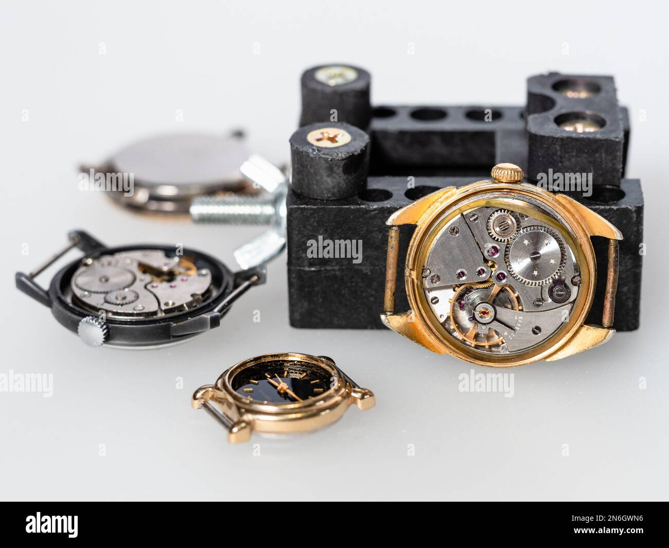 open yellow mechanical watch and old watches on white board in ...