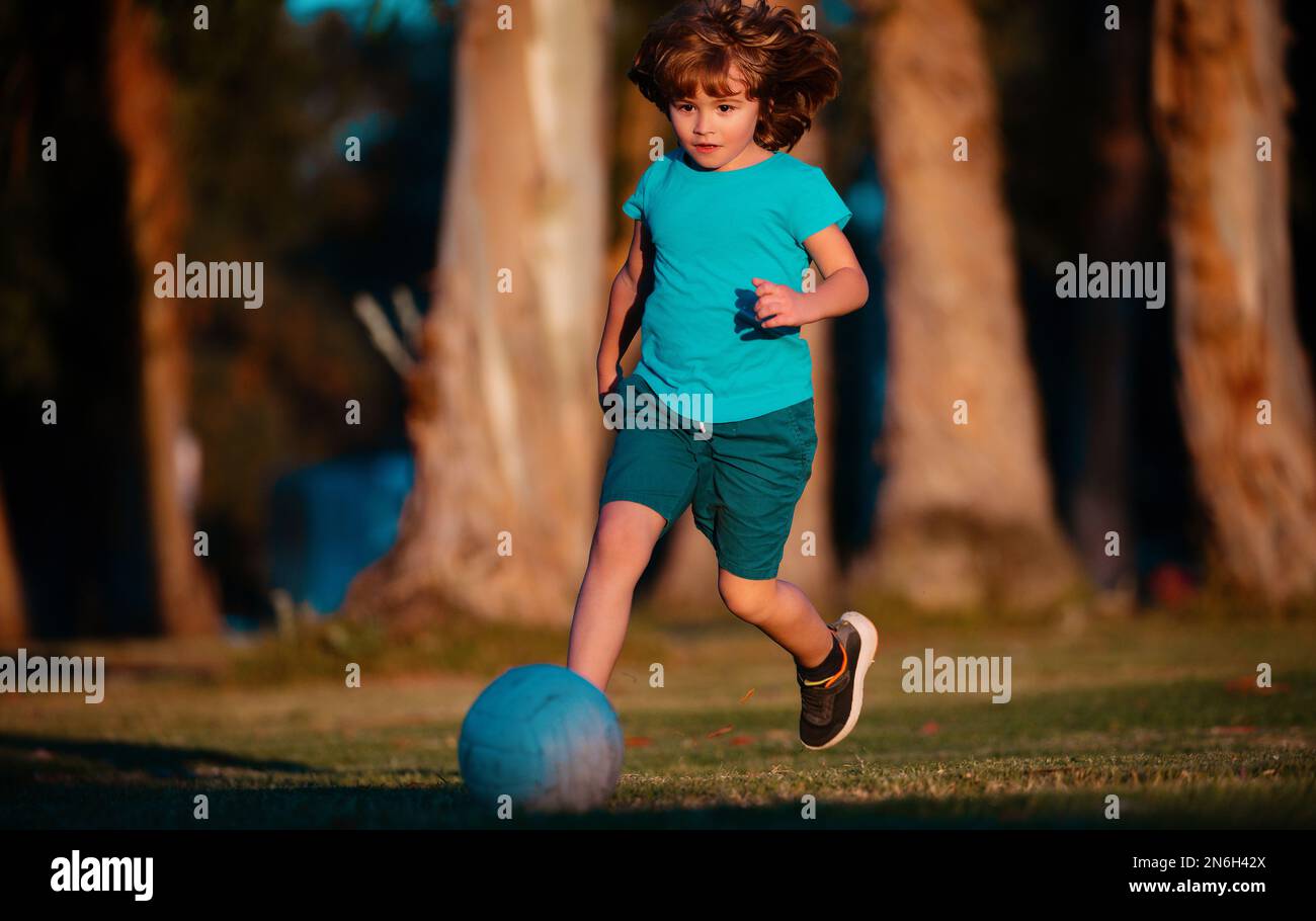 Boy child playing football on football field. Kid playing soccer. Young ...