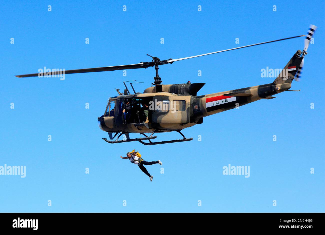 A member of Iraq's skydiving national team parachutes from a military ...