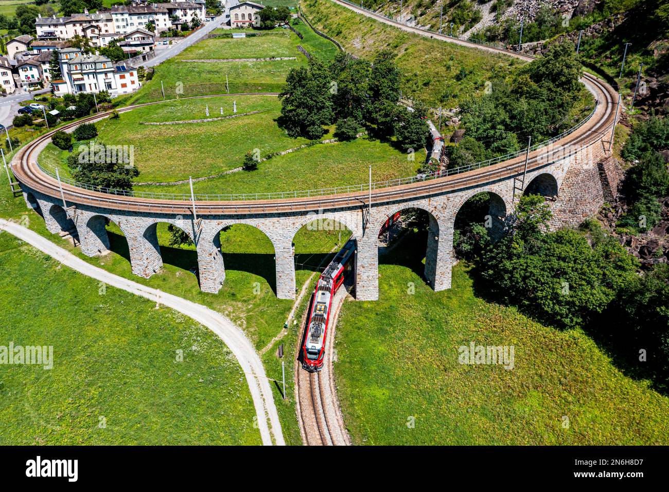 Aerial of a Train crossing the Brusio spiral viaduct, Unesco world ...