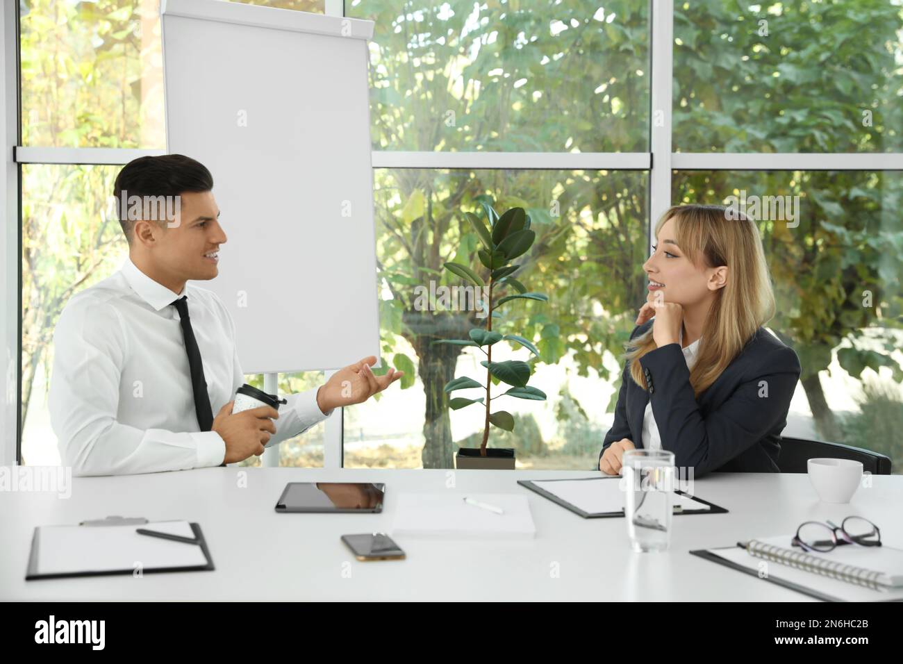 Office employees talking at table during meeting Stock Photo - Alamy