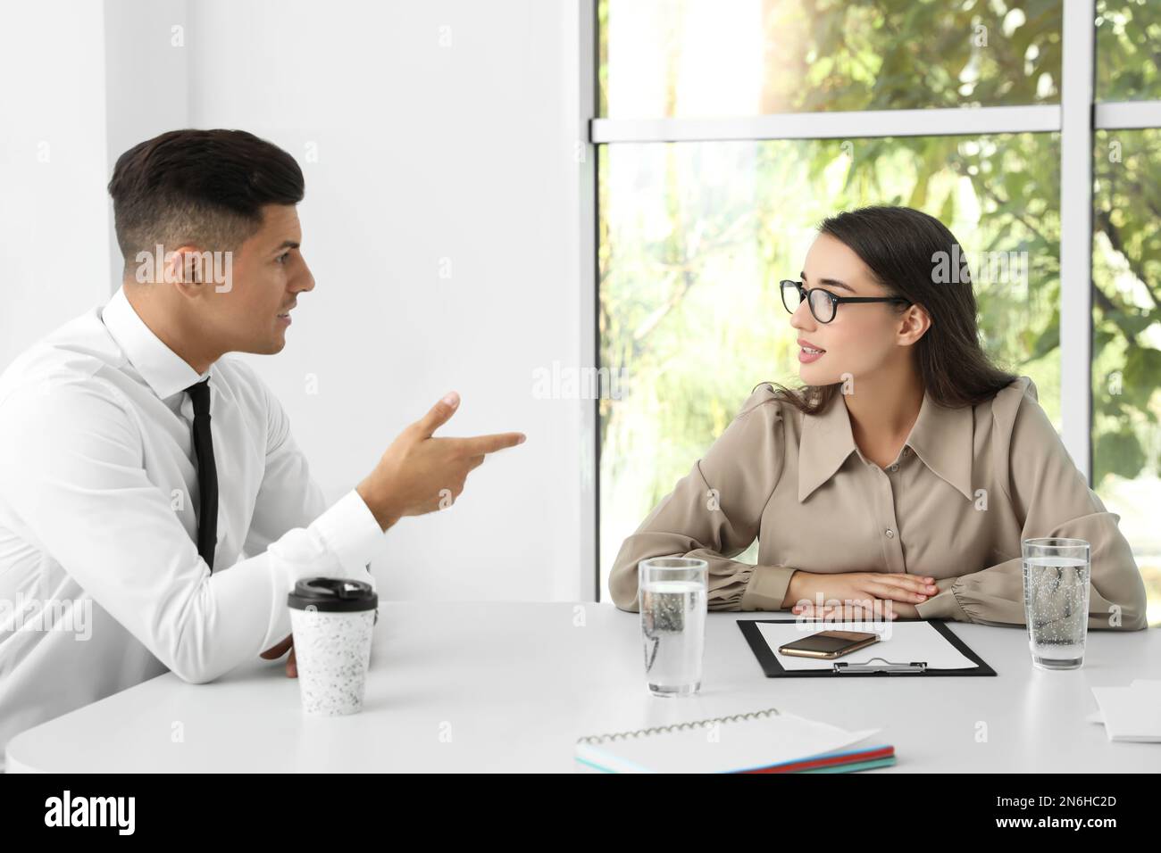 Office employees talking at table during meeting Stock Photo - Alamy