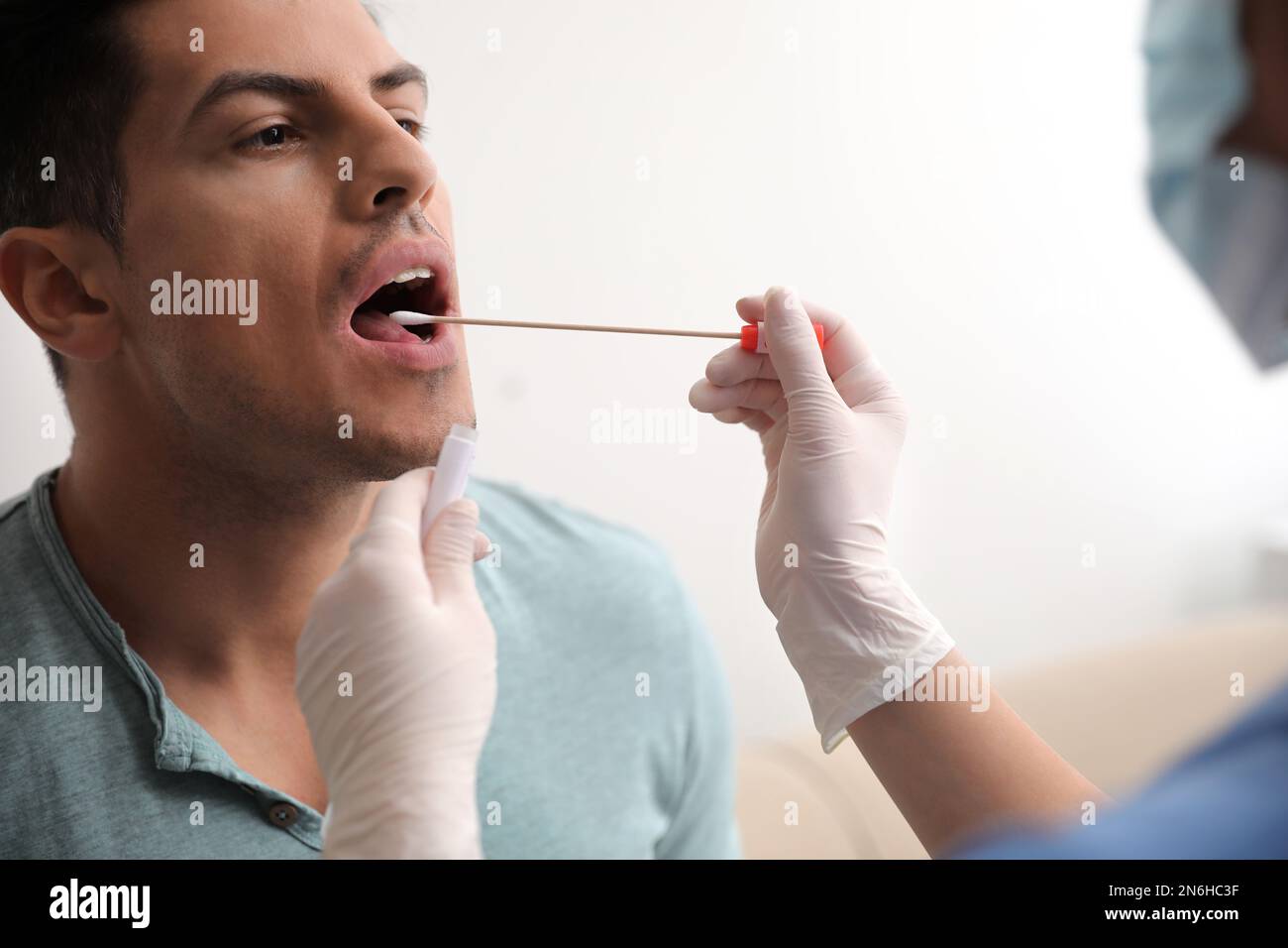 Doctor taking sample for DNA test from man in clinic Stock Photo - Alamy