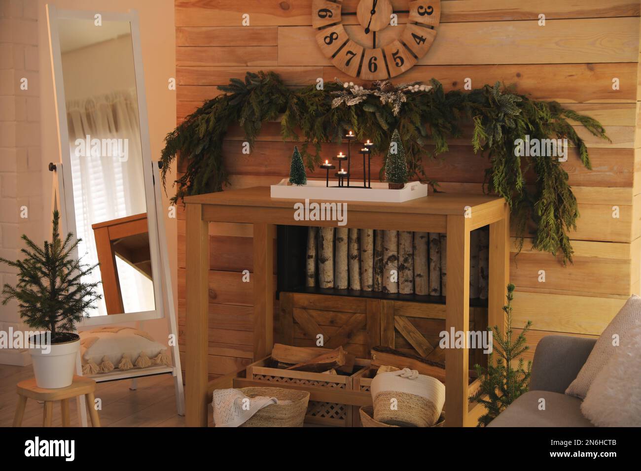 Cozy room interior with console table and conifer garland near wooden ...
