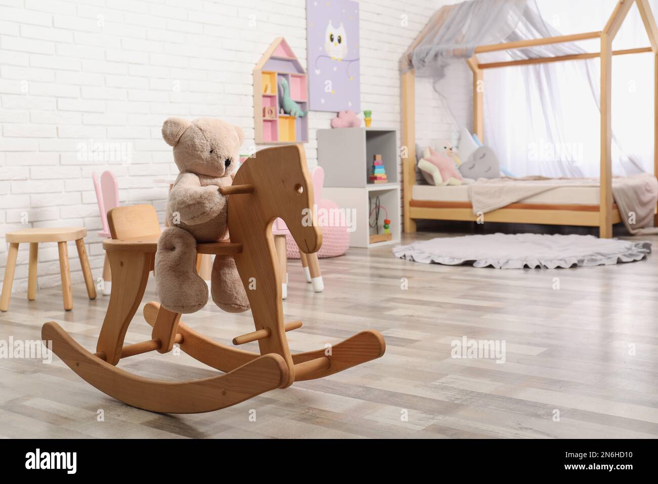 Teddy bear on wooden rocking horse in child's room, space for text ...