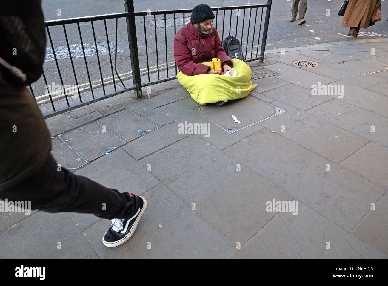 London, England, UK. Homeless man sitting on the pavement in Trafalgar ...