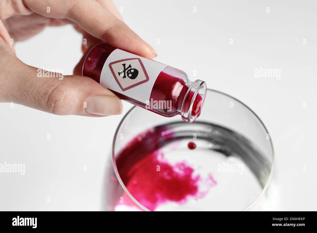 Woman pouring poison into glass of water on white background, closeup ...