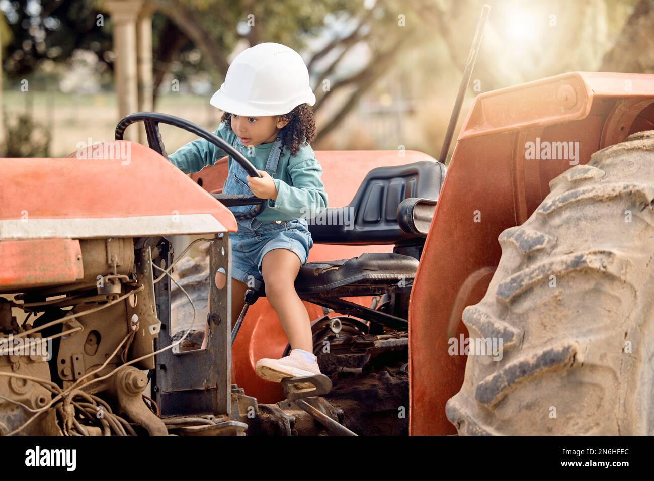 Girl child in tractor, agriculture and farming transport ...