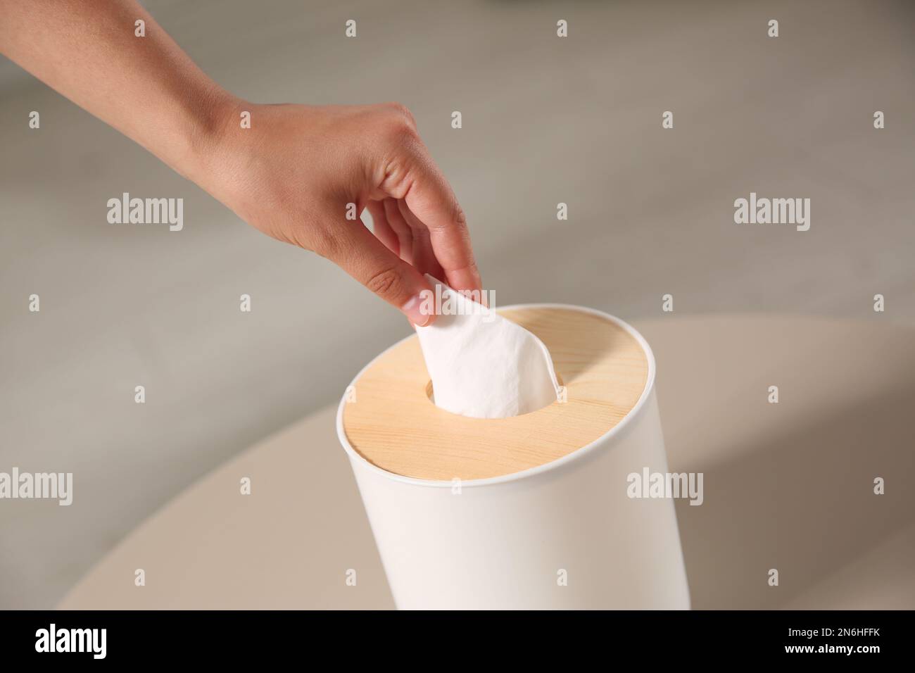 Woman taking paper tissue out of box on light table, closeup Stock ...