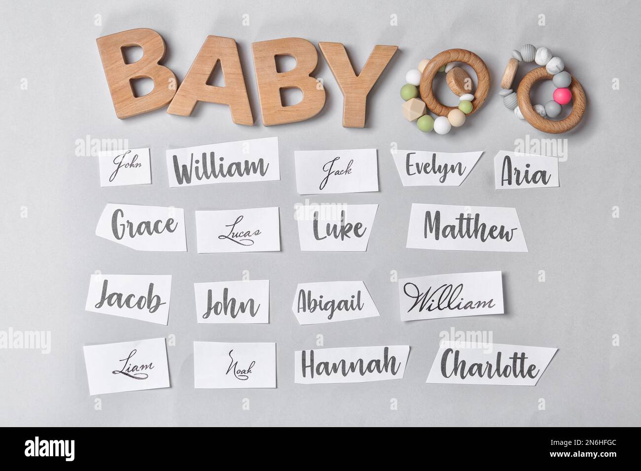Paper sheets with written different baby names, wooden letters and toys ...