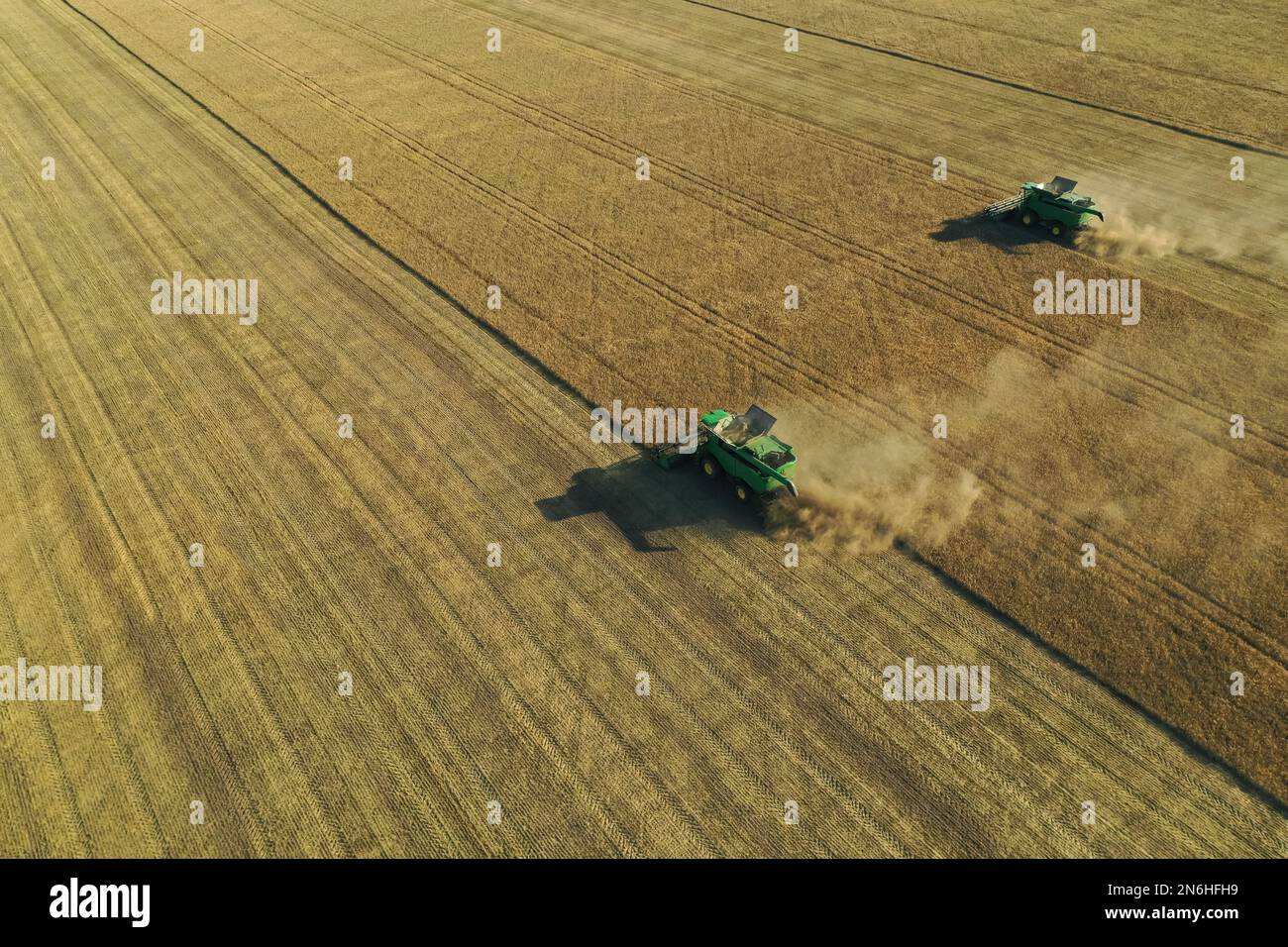 Beautiful aerial view of modern combine harvesters working in field on ...