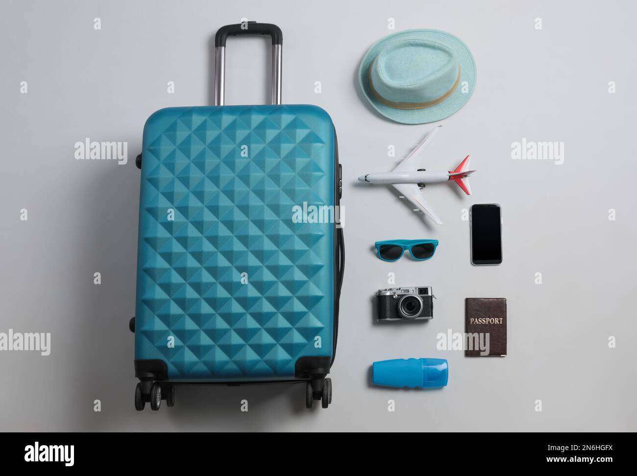 Flat lay composition with suitcase and travel accessories on grey ...