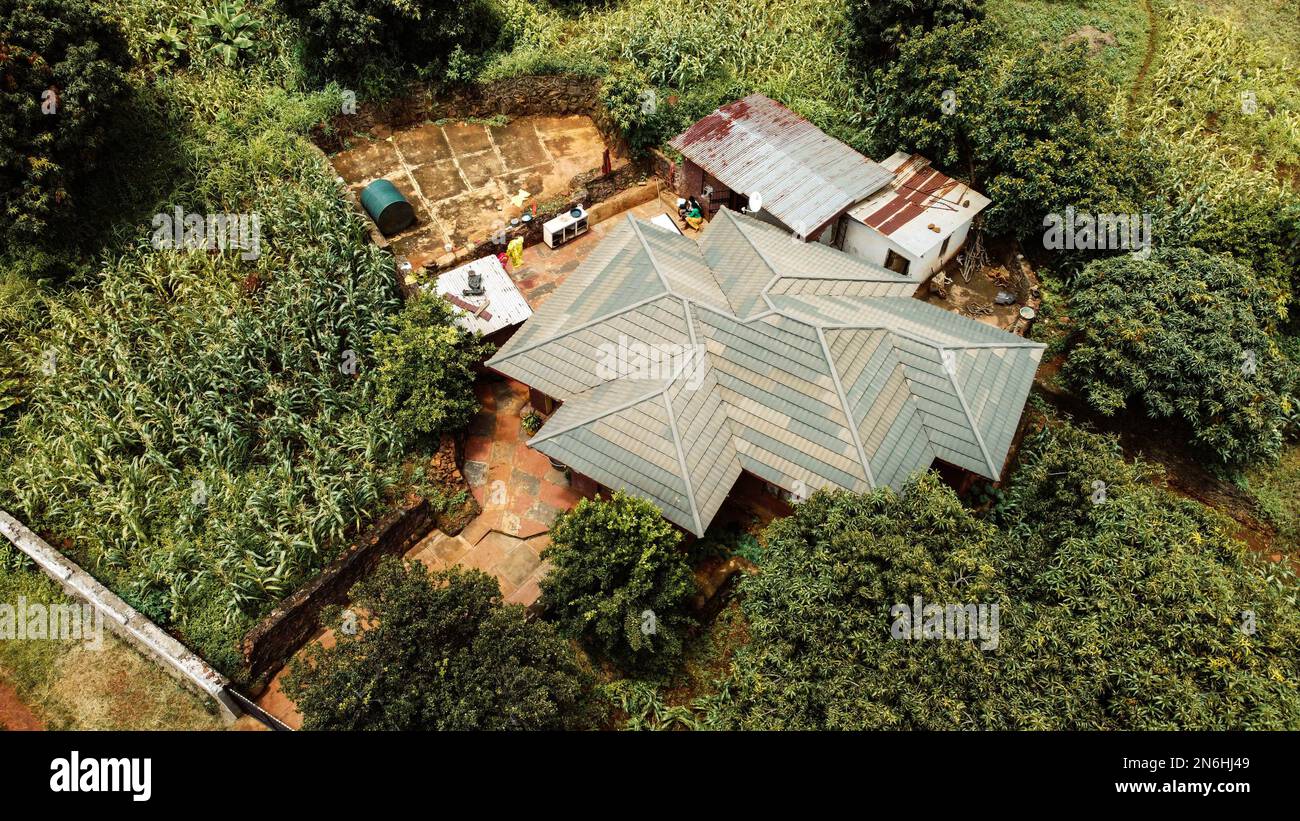 An aerial view of a house surrounded by trees and vegetation Stock ...