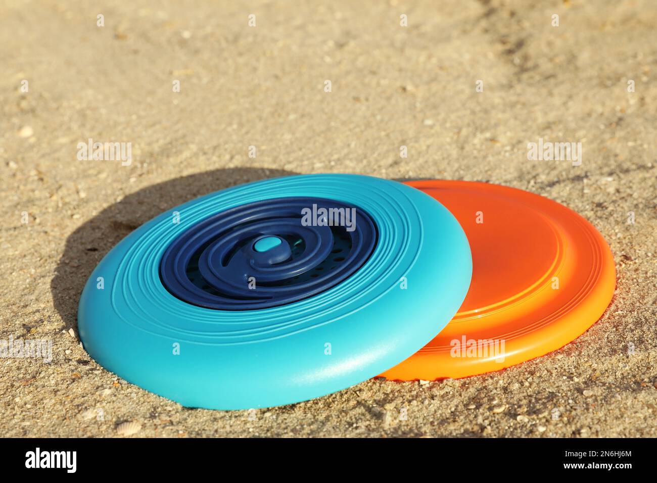 New plastic frisbee discs on sandy beach Stock Photo - Alamy