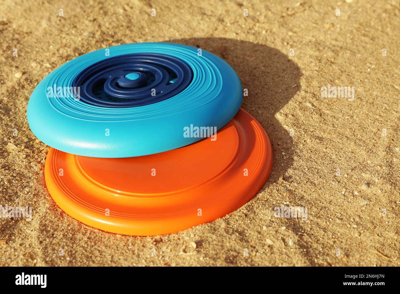 New plastic frisbee discs on sandy beach Stock Photo - Alamy