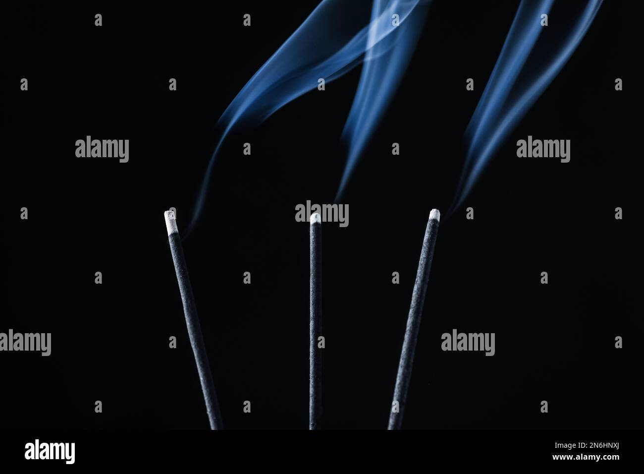 Incense sticks smoldering on black background, closeup Stock Photo - Alamy