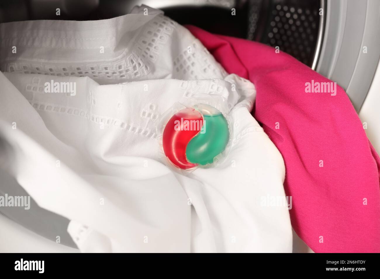 Laundry detergent capsule and clothes in washing machine Stock Photo ...