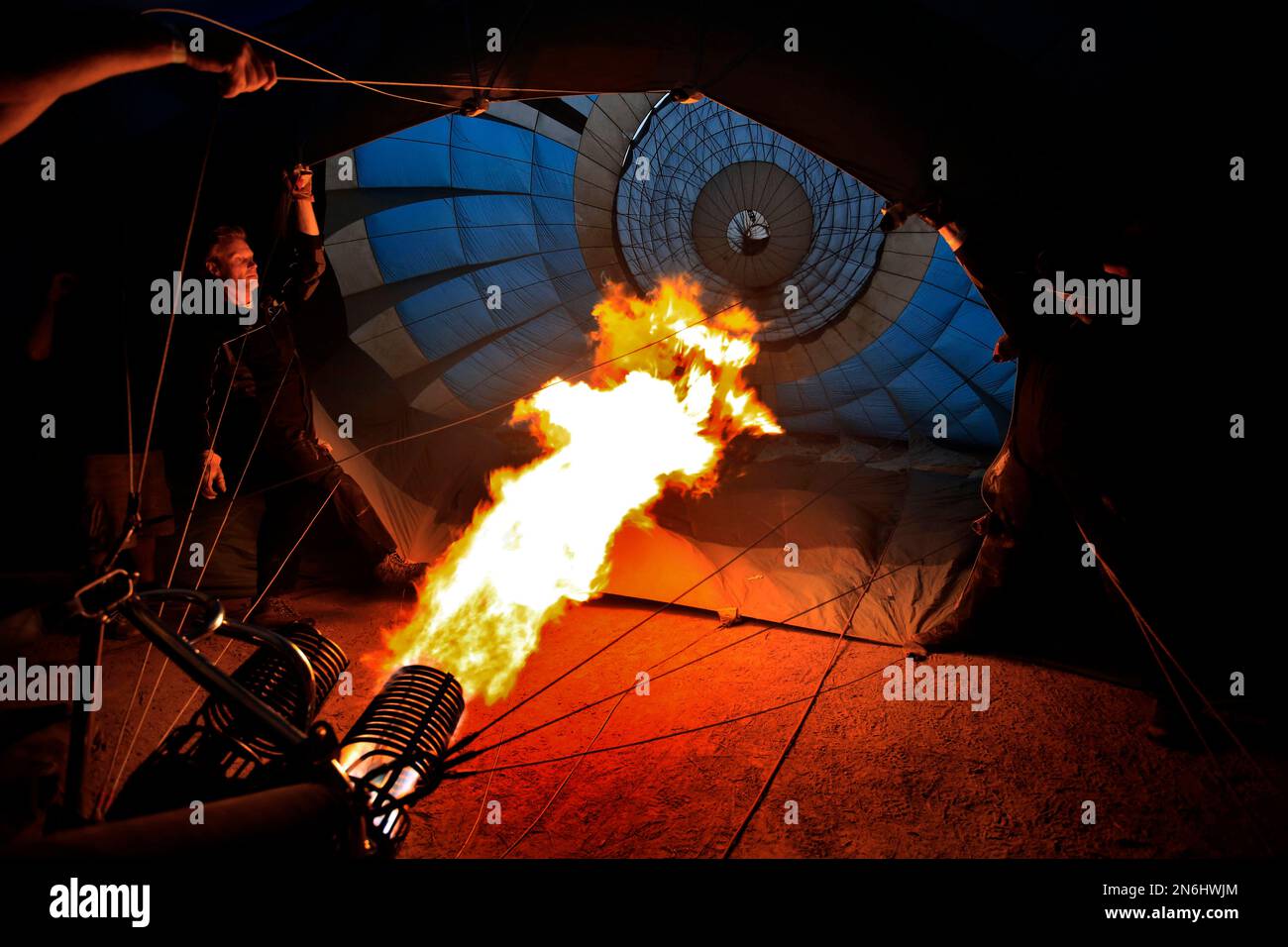 A hot air balloon crew member works ahead of take off during a festival ...