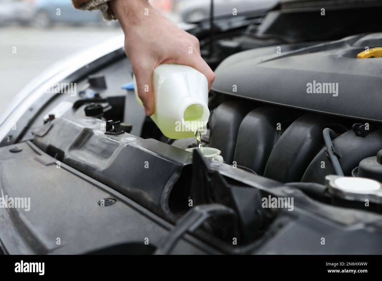 Man filling car radiator with antifreeze outdoors, closeup Stock Photo ...