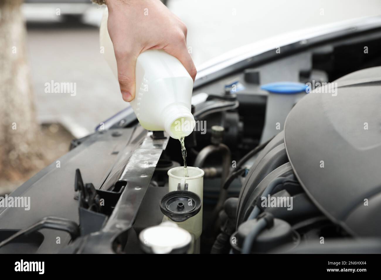 Man filling car radiator with antifreeze outdoors, closeup Stock Photo ...