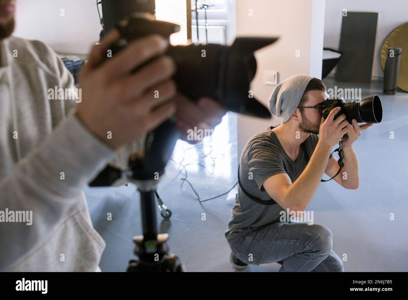 Photographer shooting at studio photo session Stock Photo - Alamy