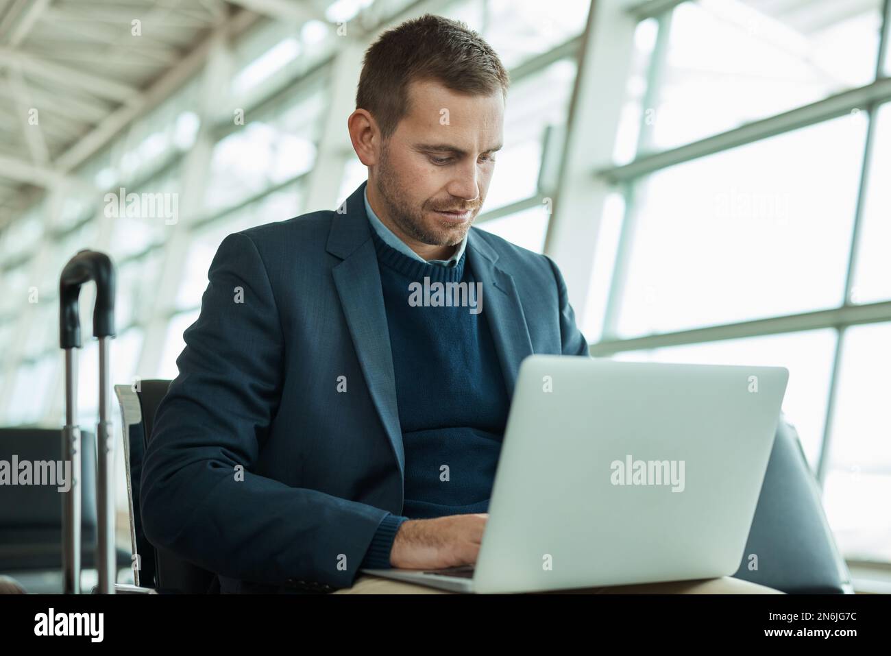 Business man, airport and laptop for travel while working in lobby to ...