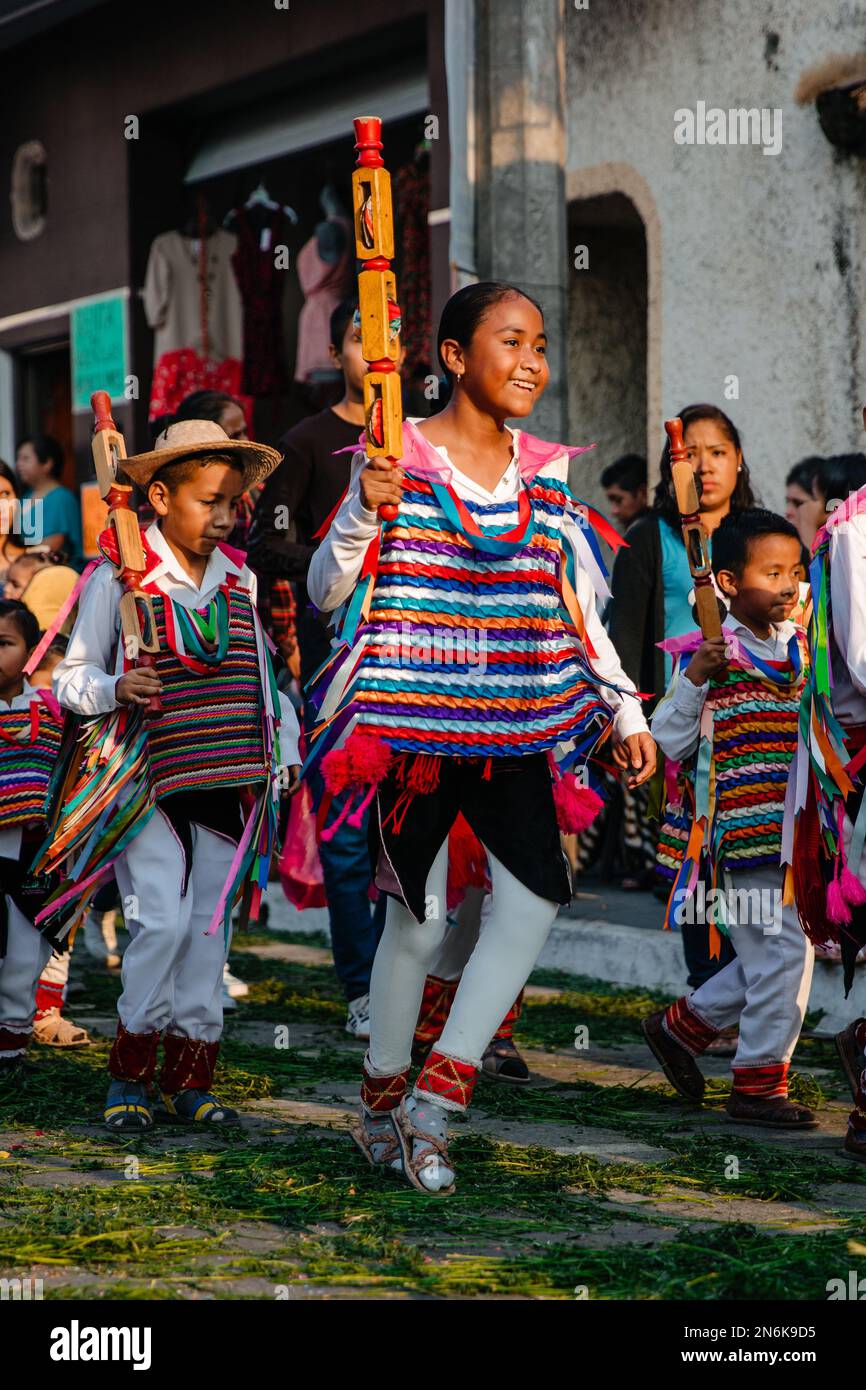 A group of Mexican young people in traditional outfits performing ...