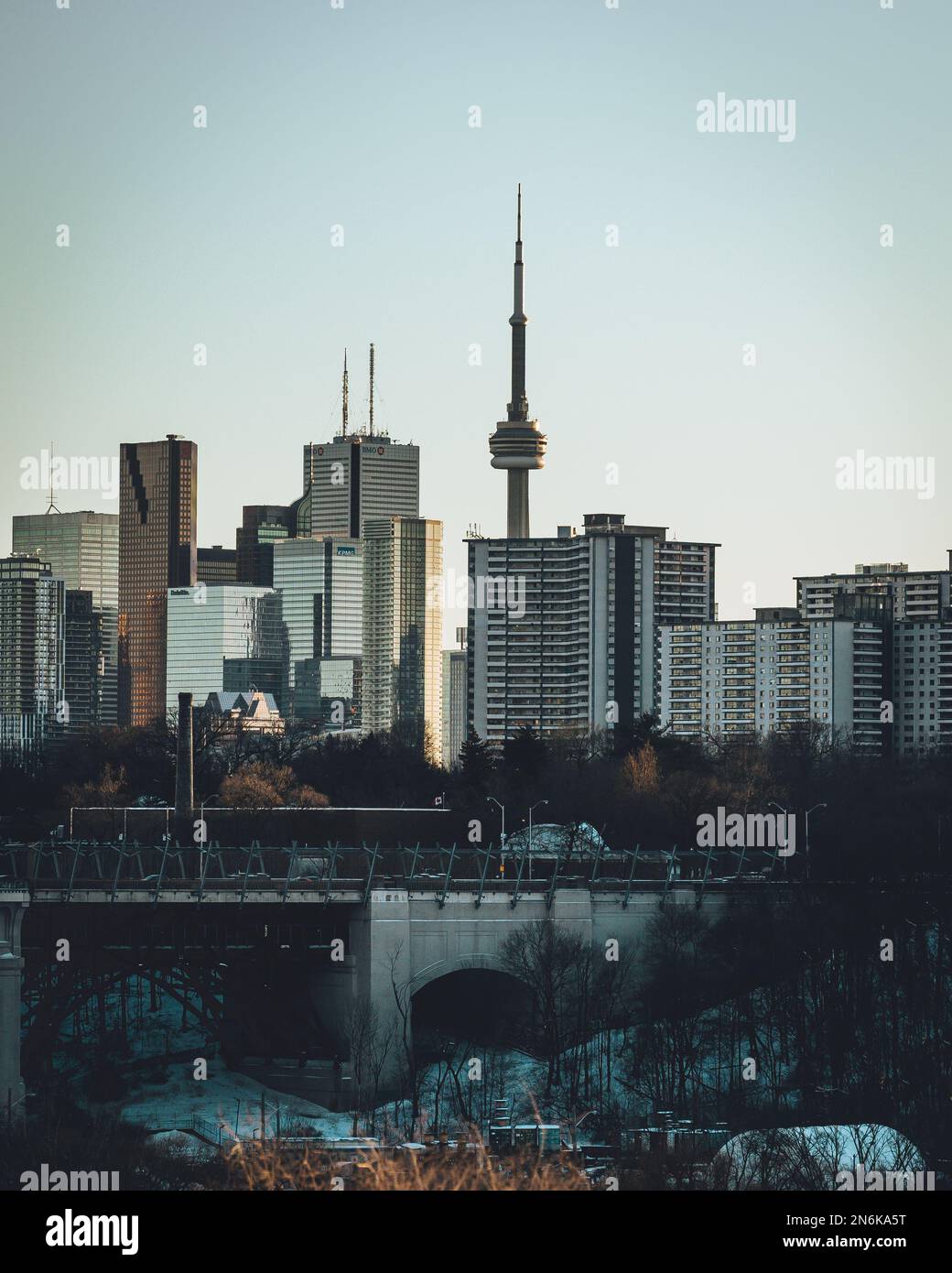 A vertical drone shot of the CN tower and other buildings in winter in ...