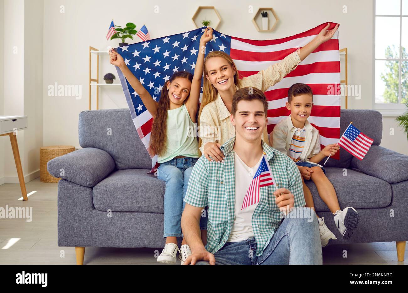 Portrait of happy young American family with children who are holding ...