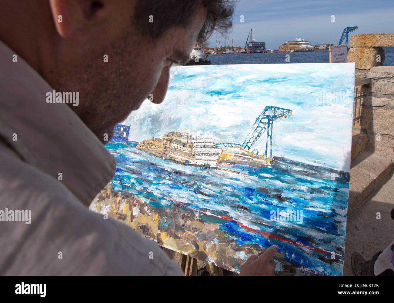 Artist Nino Taravella works at a painting of the Costa Concordia ship ...